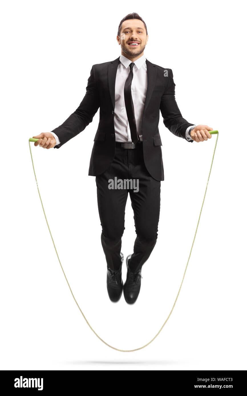 Full length portrait of a young man in a suit skipping a rope and ...
