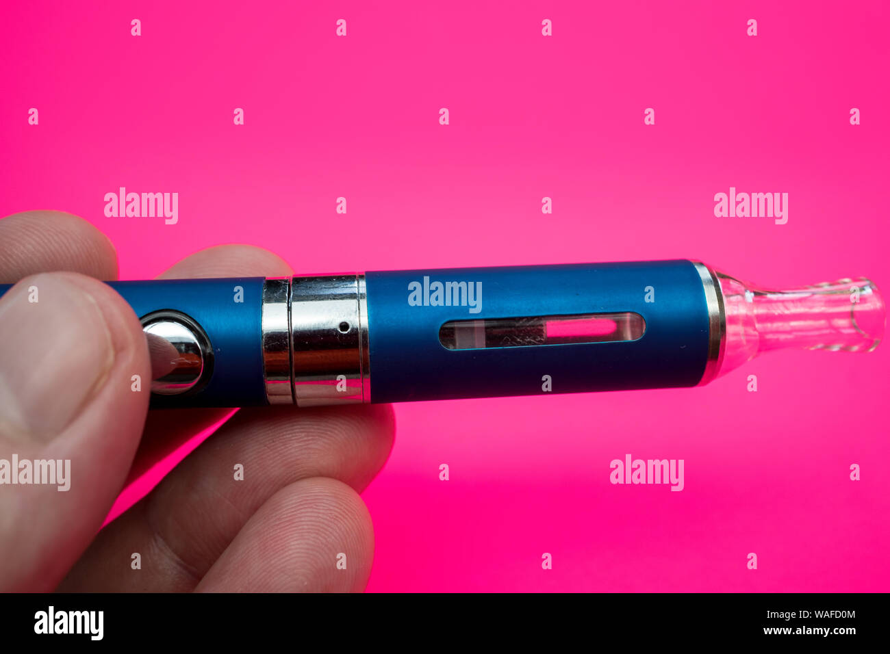 Hand holding vape pen metal electronic cigarette with vaping pink ...