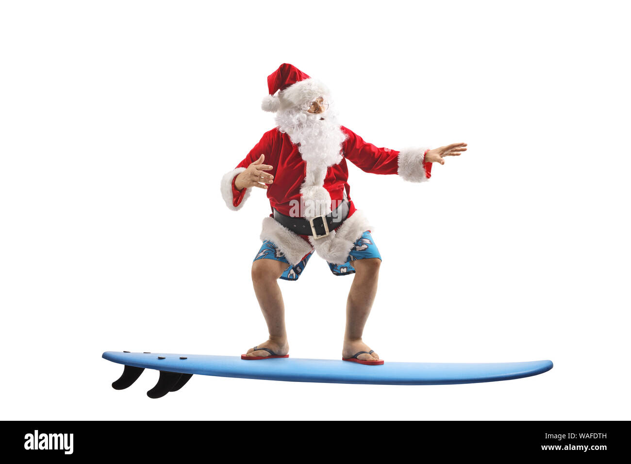 Full length shot of Santa Claus in swimming shorts on a surfboard ...