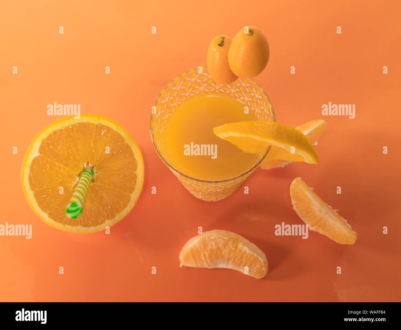 Top view of small oranges, orange juice and sliced oranges on an orange ...
