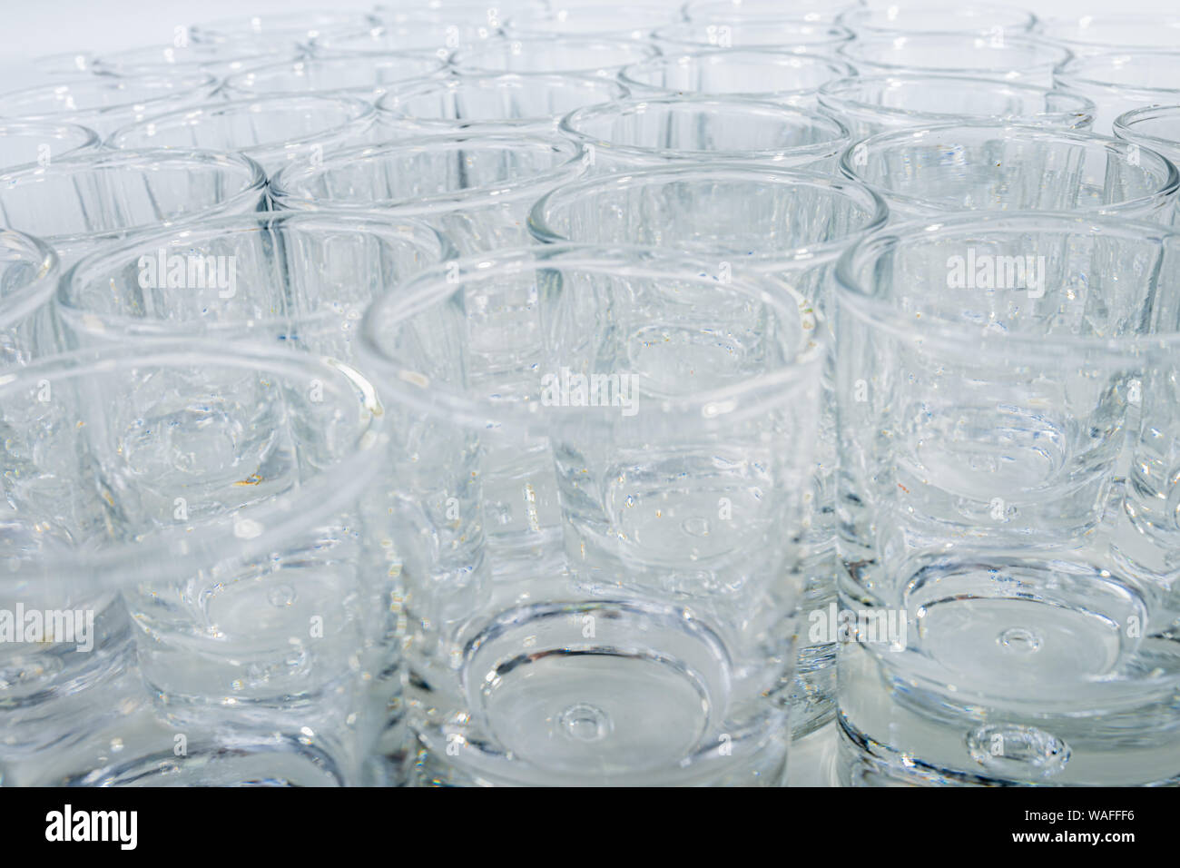 Close-up of many glass cups on a white background - Luxurious, shiny ...