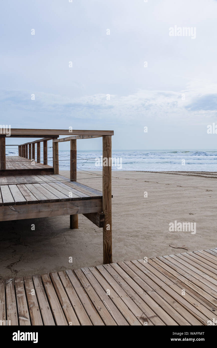 Wooden dock on the sand sea coast at sunset - Vertical image Stock ...