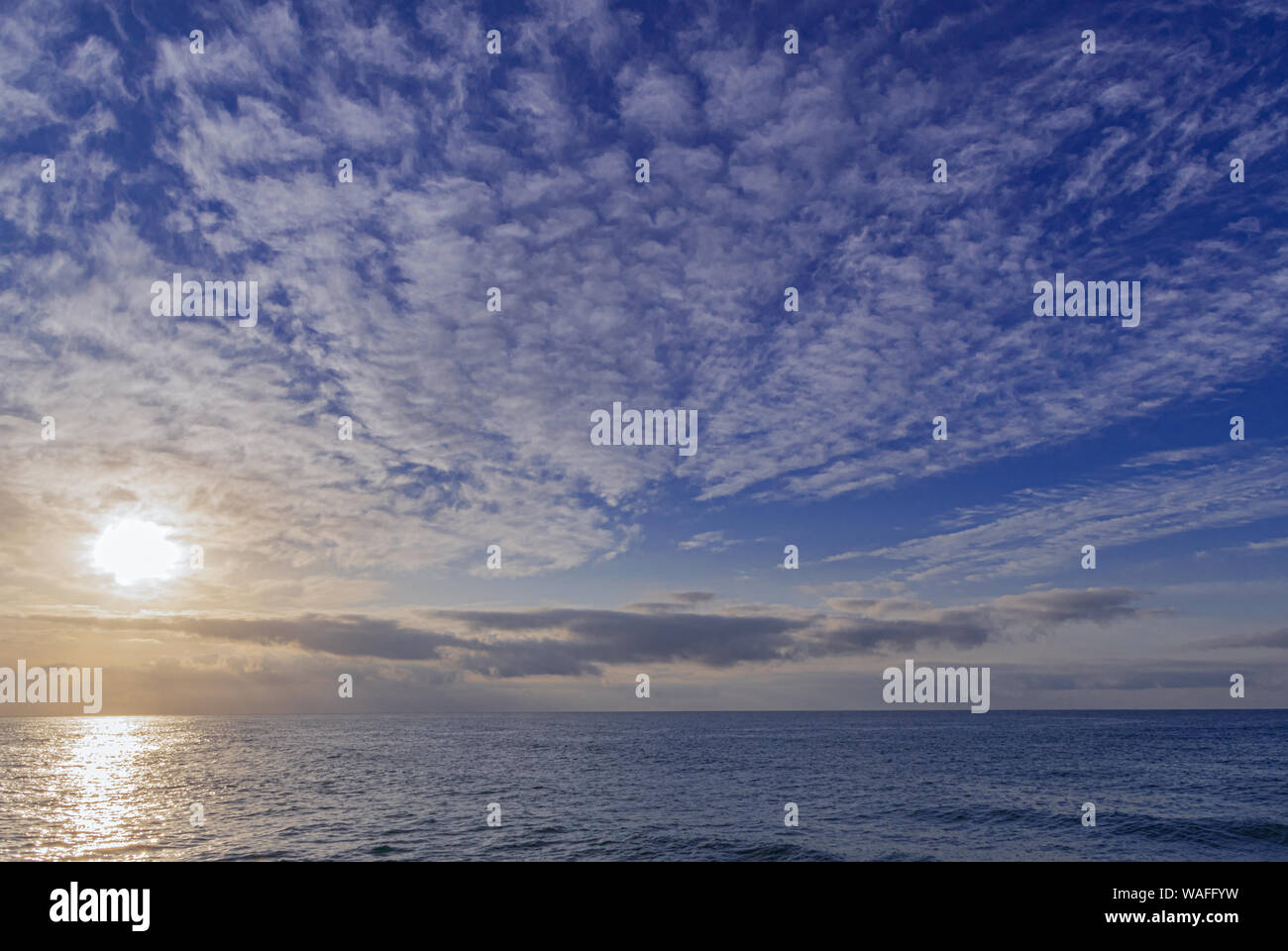 Colorful photo of a majestic sky full of clouds and the sea reflecting ...
