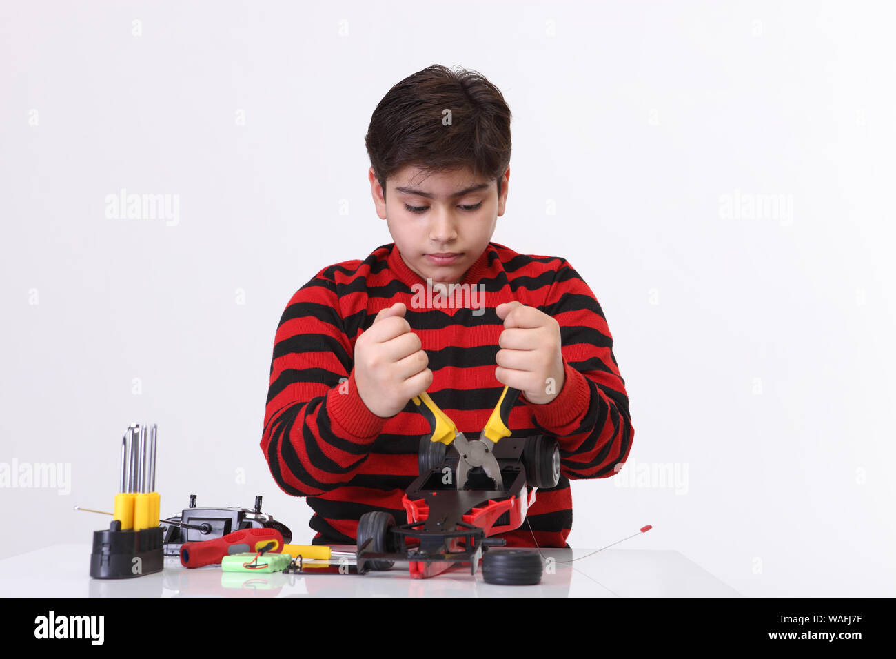 Boy repairing his toy car Stock Photo - Alamy