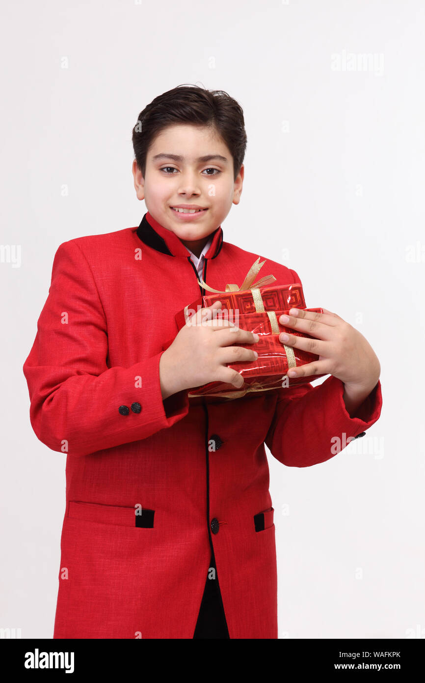 Boy holding gift boxes and smiling Stock Photo - Alamy
