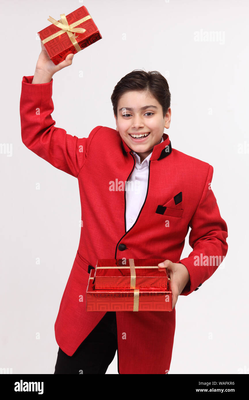 Boy holding gift boxes and smiling Stock Photo - Alamy