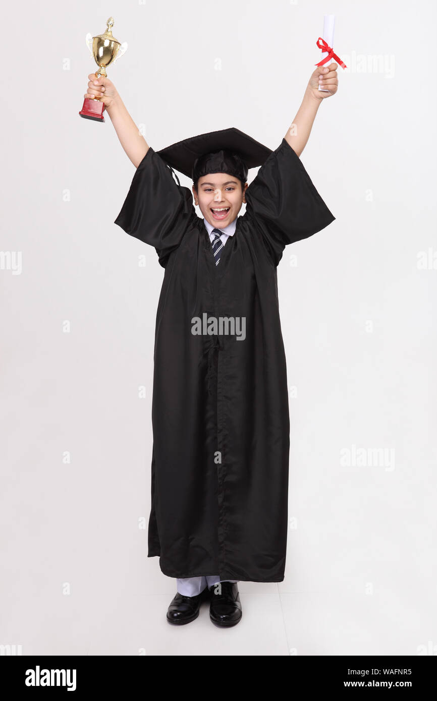 Boy in graduation gown showing a degree with trophy Stock Photo - Alamy