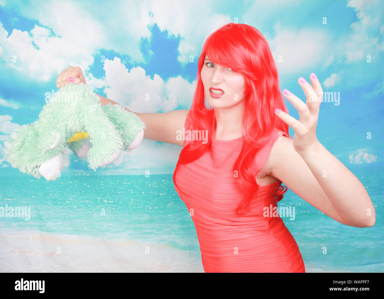 female with red long hair unhappy with her toy teddy-bear and has ...