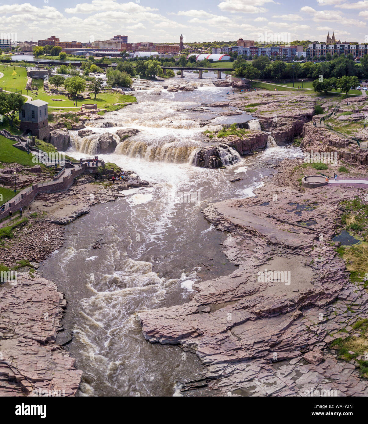 Low aerial view of the waterfall and Falls Park in Sioux Falls, South ...