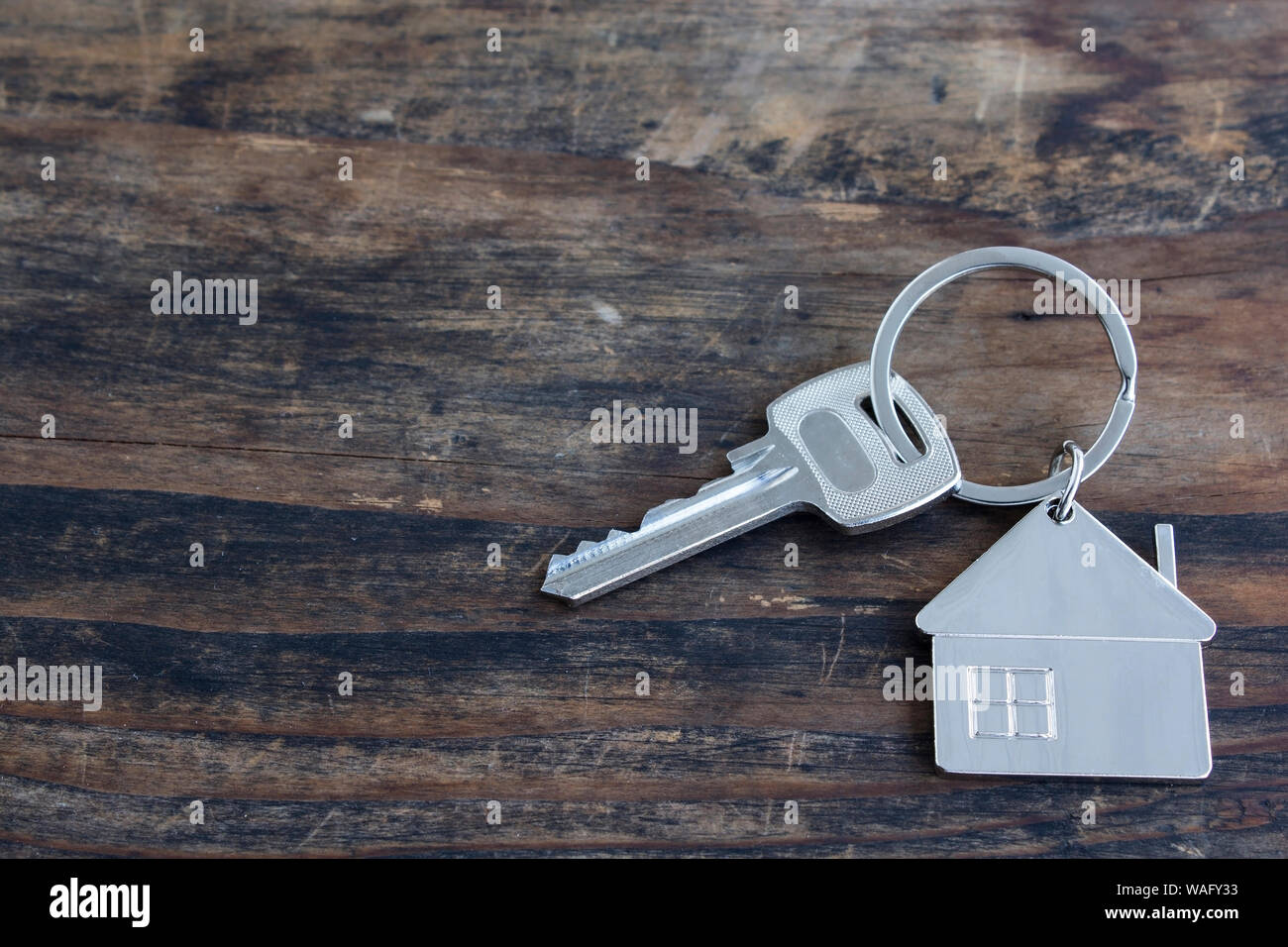Key and House Pendant on a Rustic Wooden Background Stock Photo - Alamy