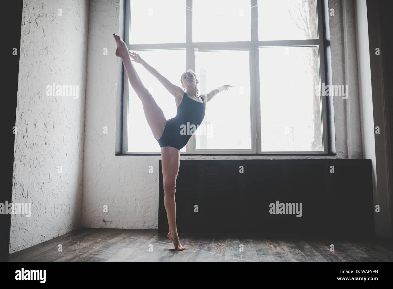 Plasticity slim woman dancing near window. Professional dancer enjoy ...
