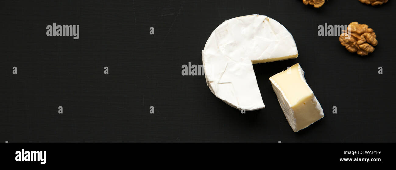 Cheese camembert or brie with walnuts on a black background. Milk ...