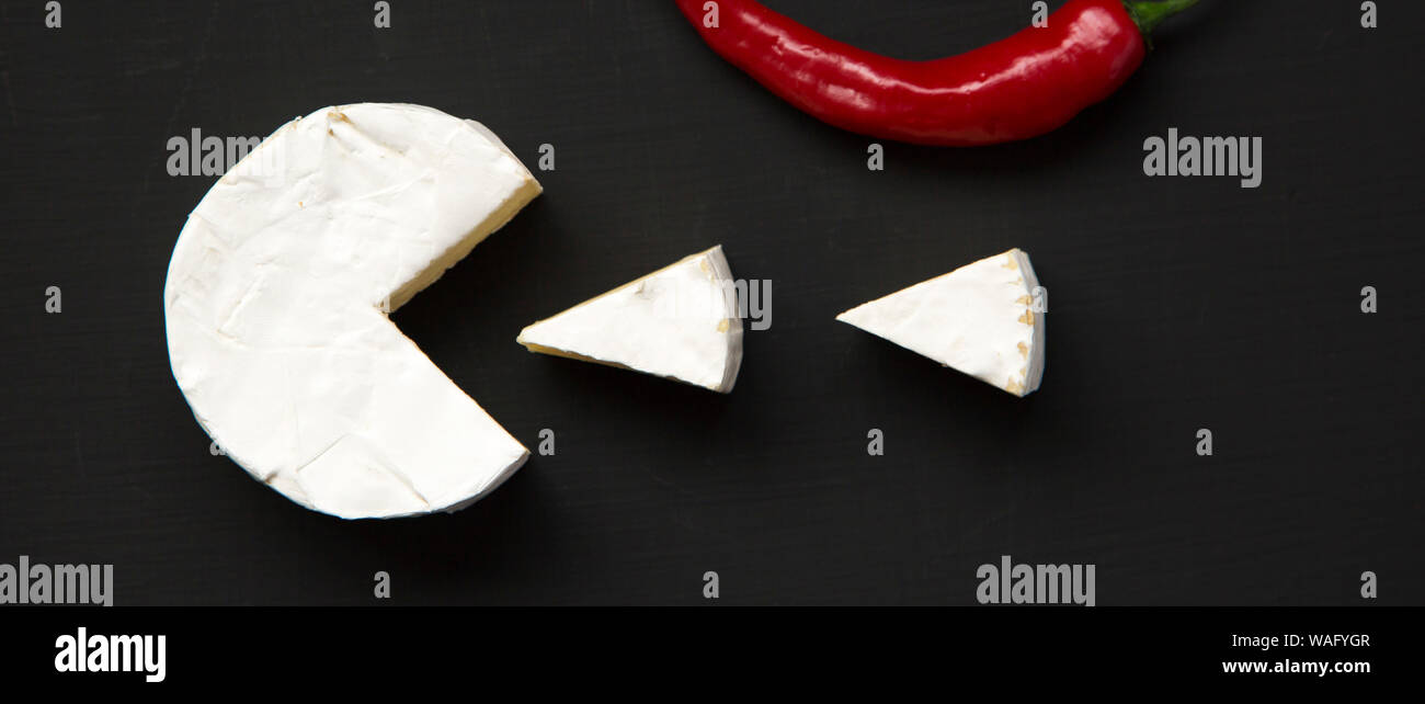 Cheese camembert or brie with chili pepper on a black background. Top ...