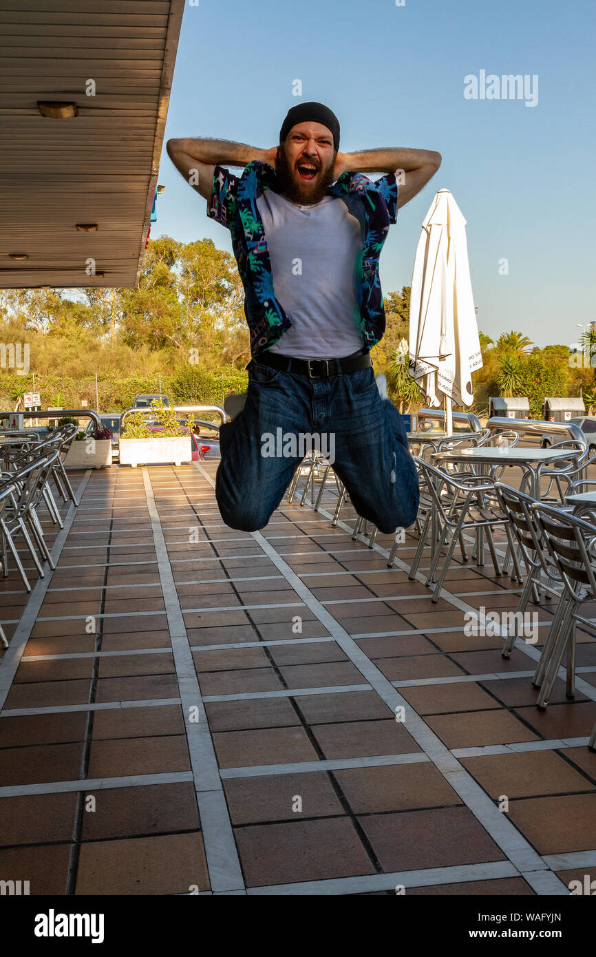 young man jumping happy with beard and headscarf Stock Photo - Alamy
