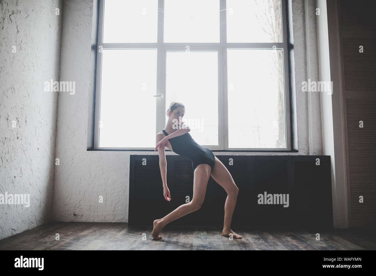 Plasticity slim woman dancing near window. Professional dancer enjoy ...
