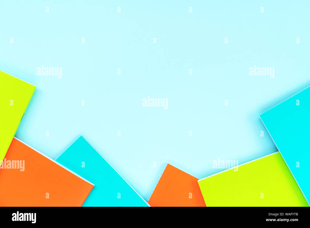 Multicolored school notebooks on a pastel sky blue background Stock ...