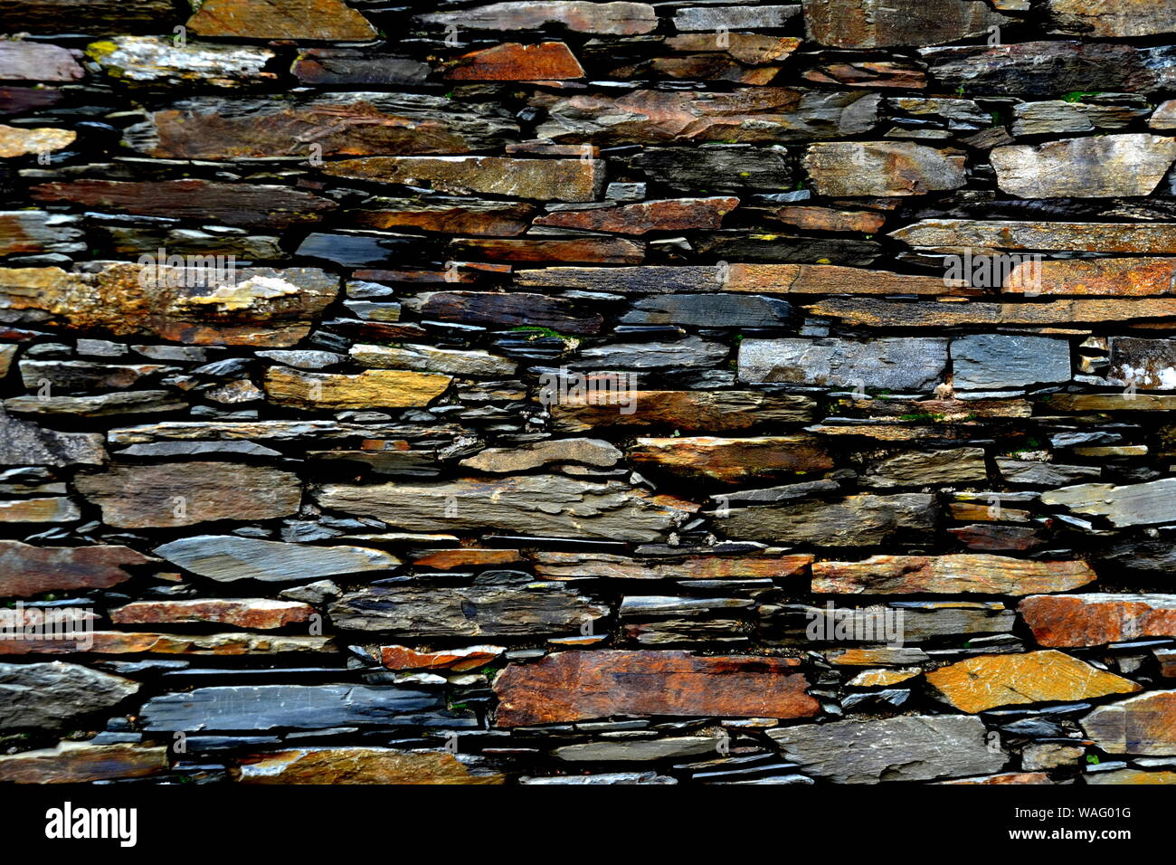 Close-up detail view of an old traditional stone wall built from schist ...