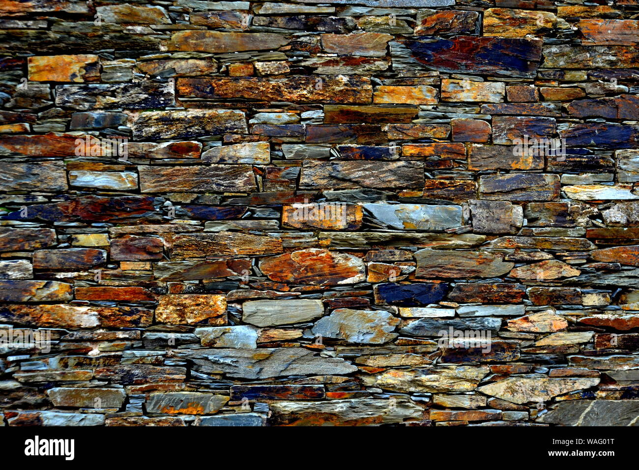 Close-up detail view of an old traditional stone wall built from schist ...