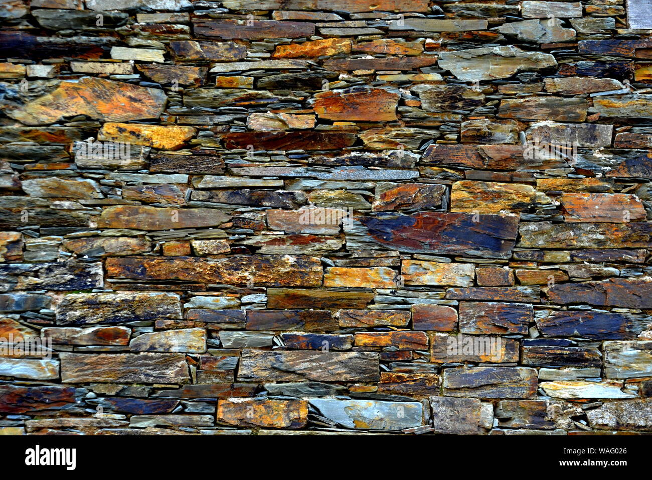 Close-up detail view of an old traditional stone wall built from schist ...