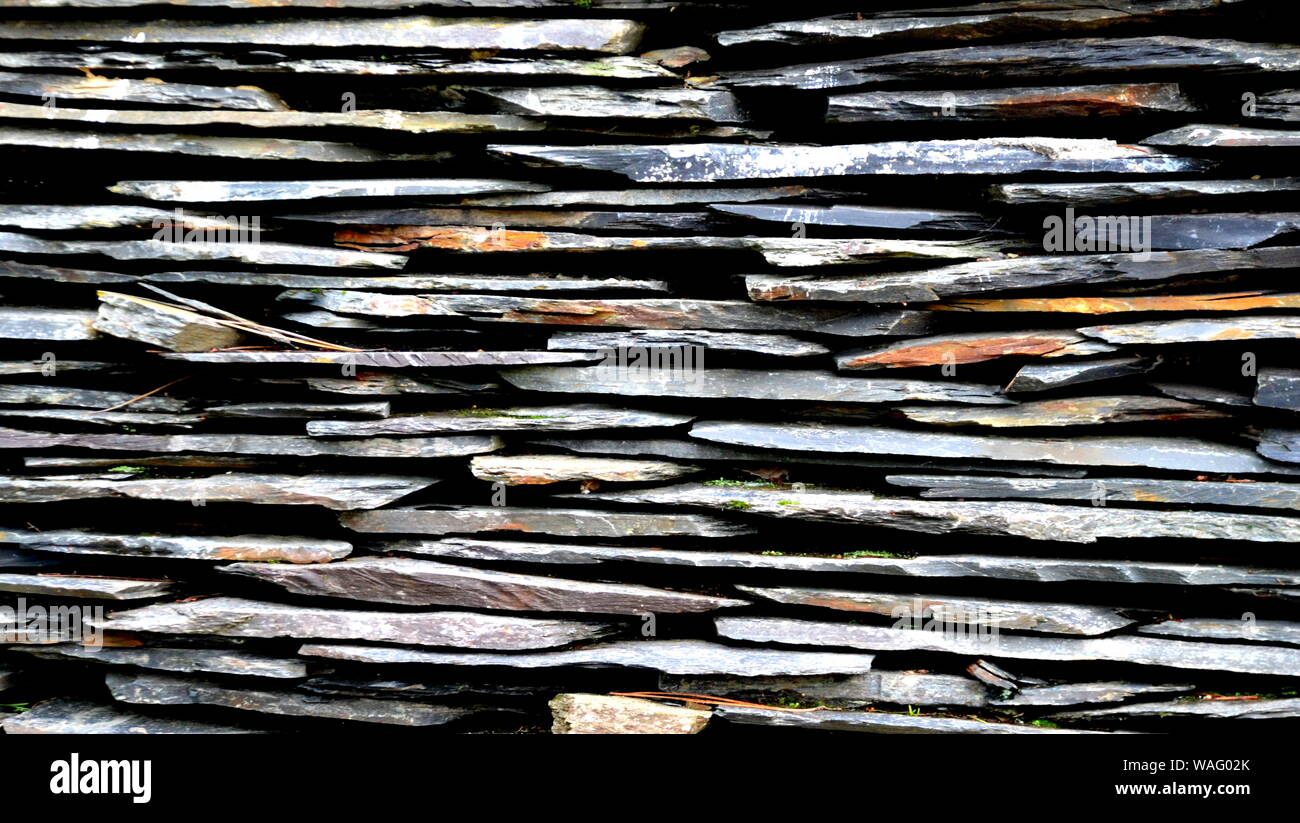 Close-up detail view of an old traditional stone wall built from schist ...