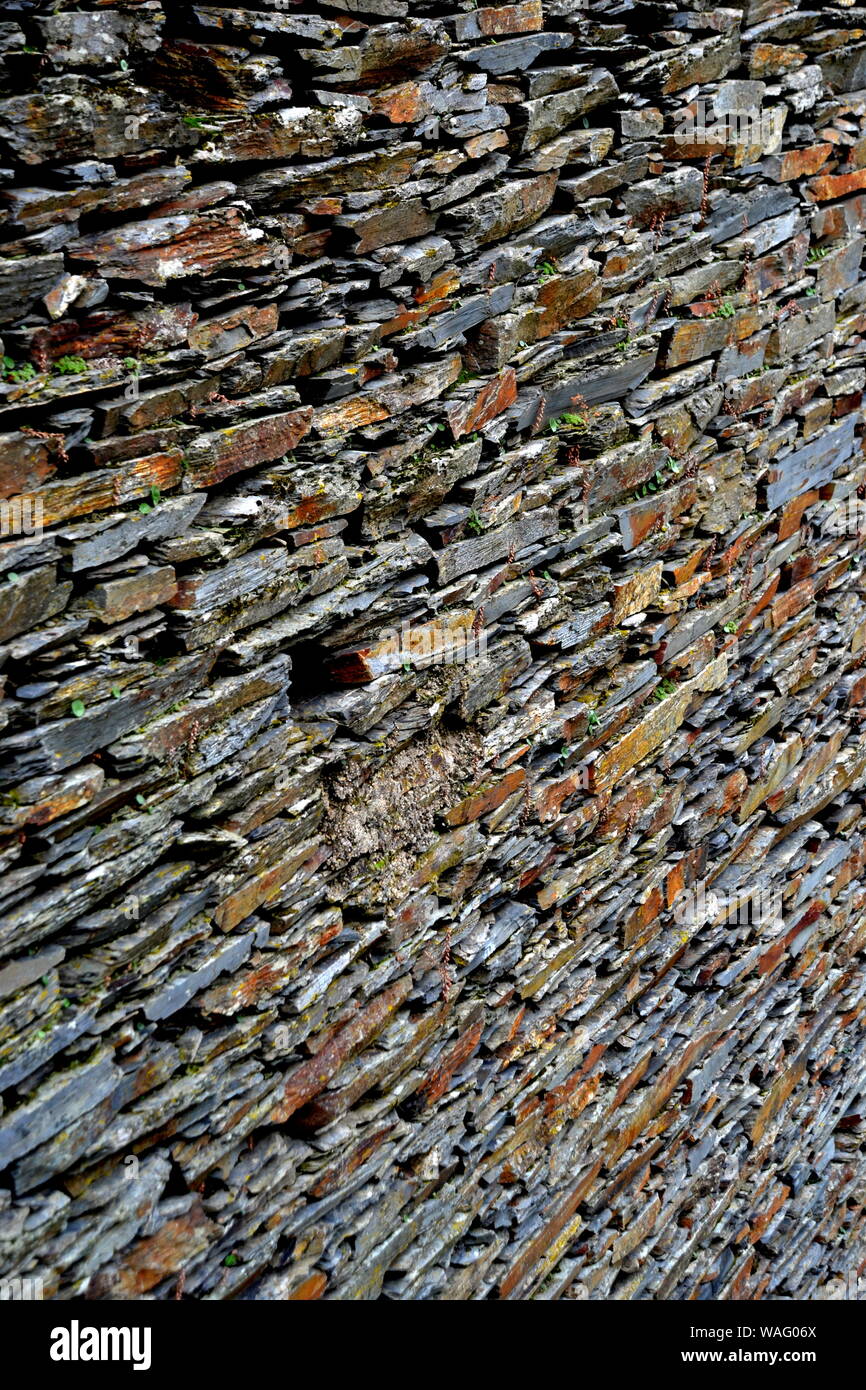 Close-up detail view of an old traditional stone wall built from schist ...