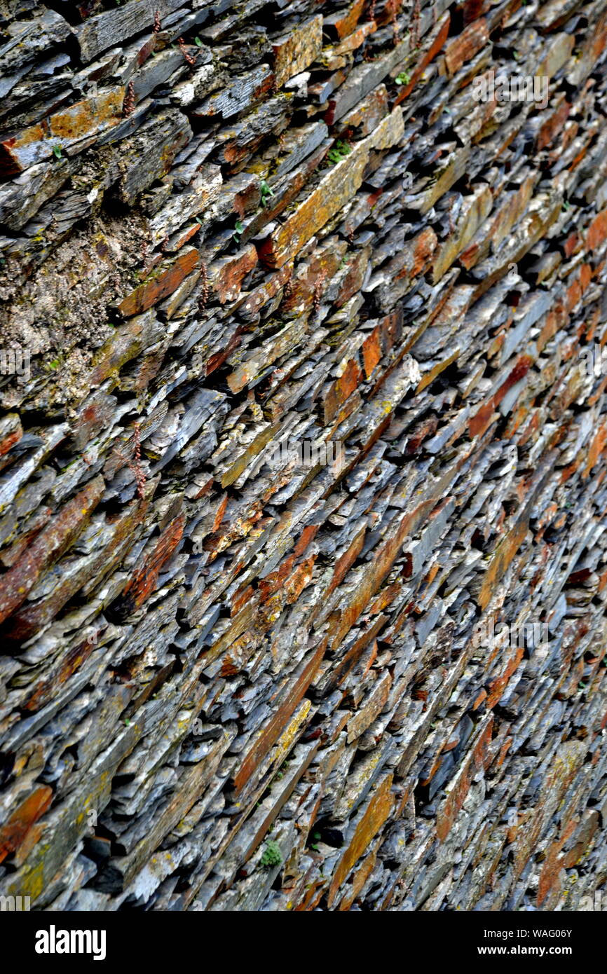 Close-up detail view of an old traditional stone wall built from schist ...