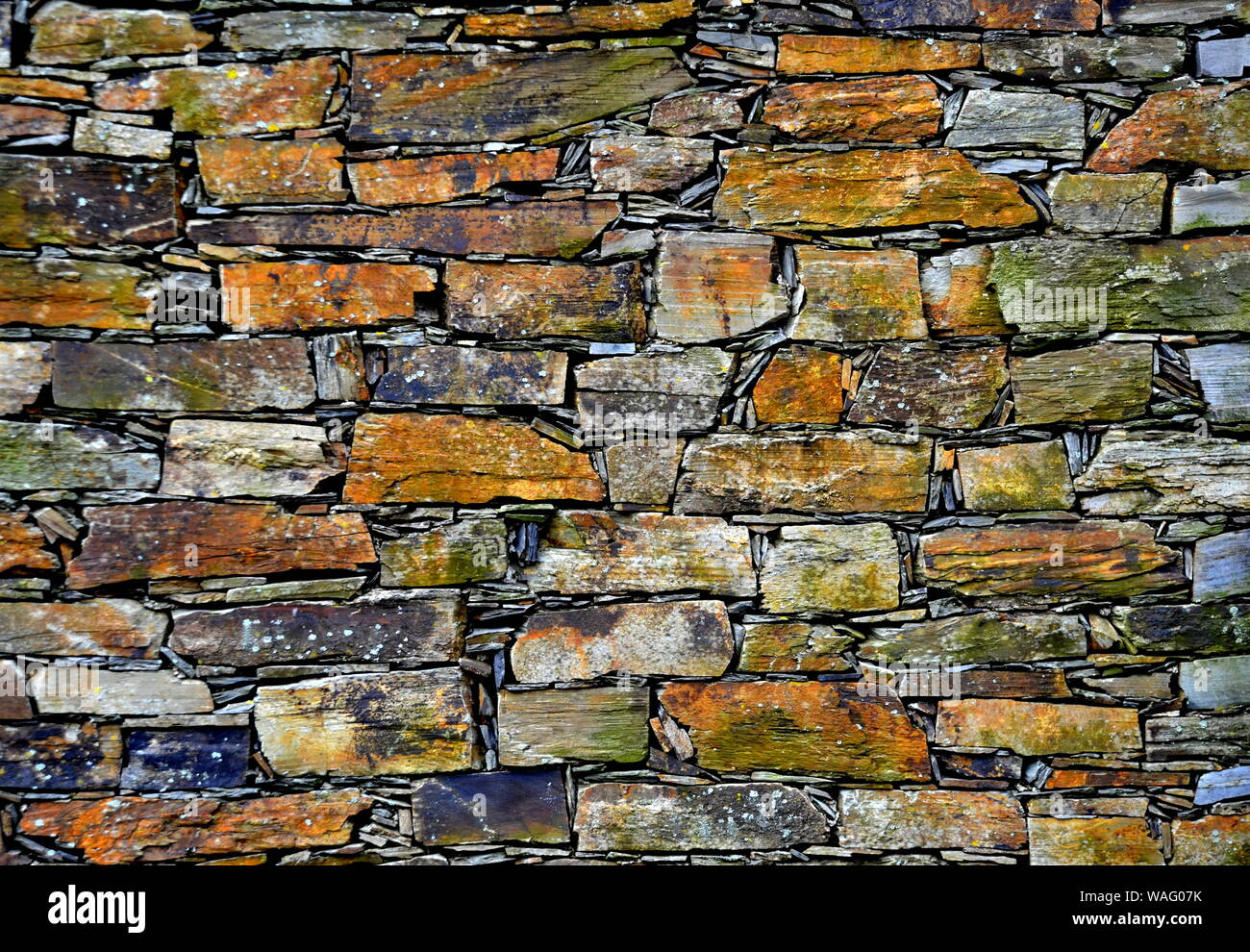 Close-up detail view of an old traditional stone wall built from schist ...