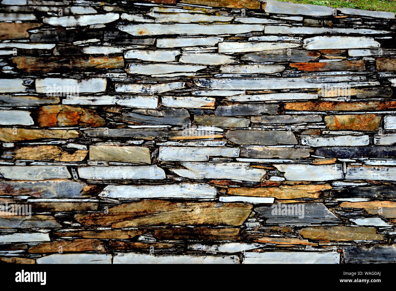Close-up detail view of an old traditional stone wall built from schist ...