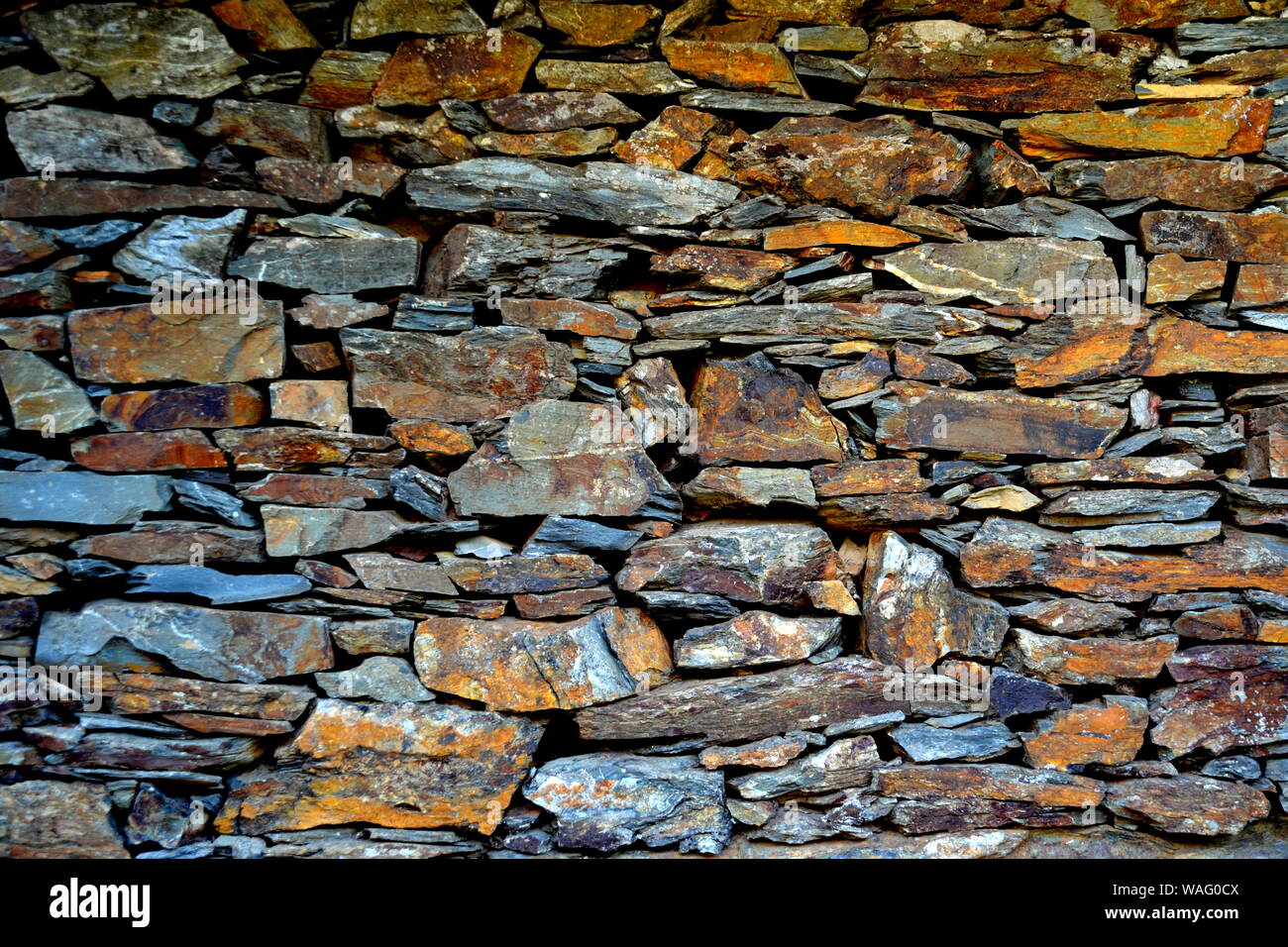 Close-up detail view of an old traditional stone wall built from schist ...