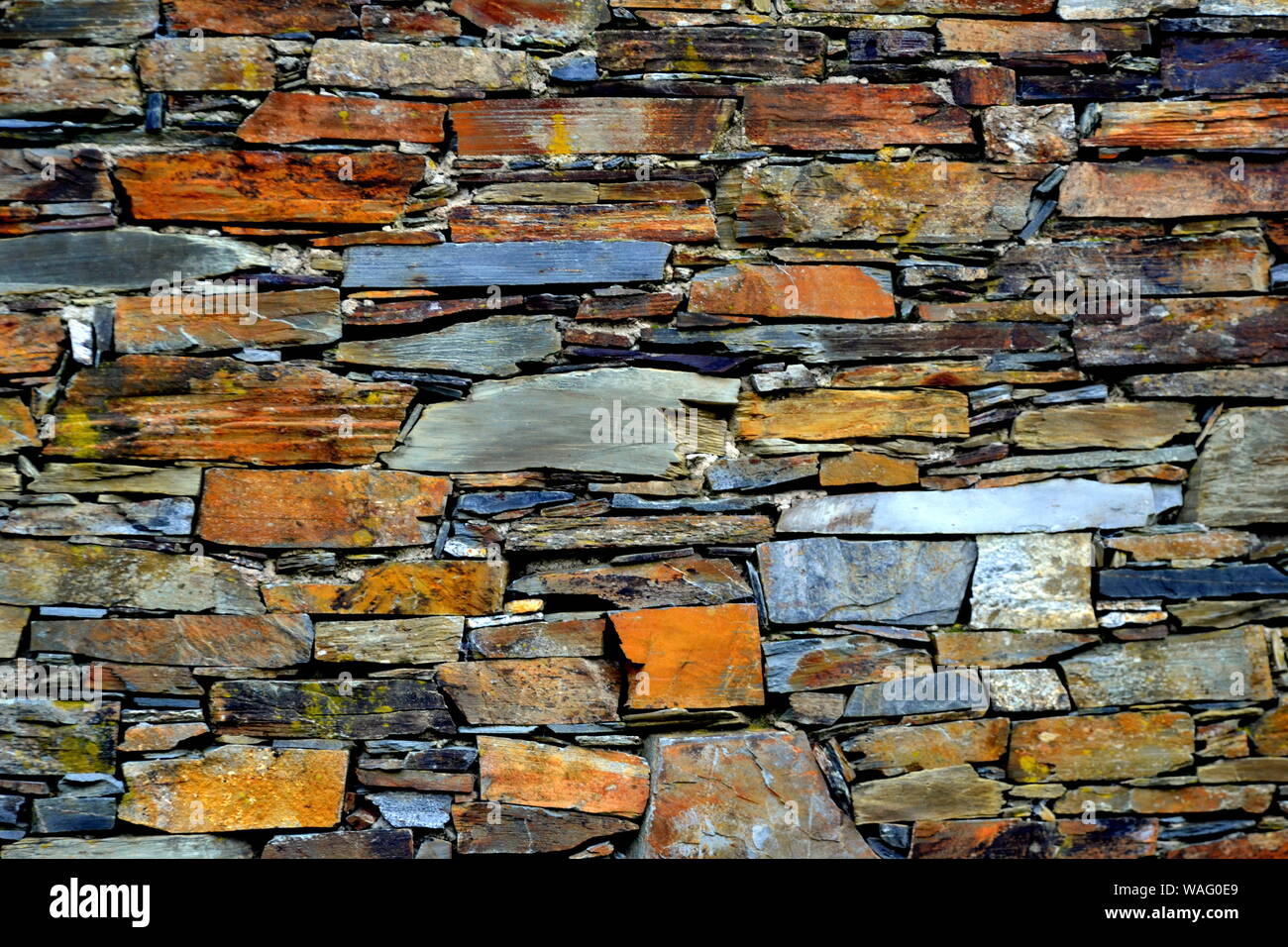 Close-up detail view of an old traditional stone wall built from schist ...