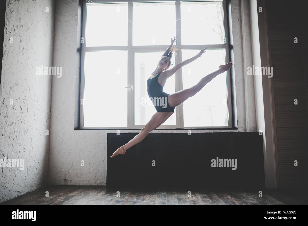 Plasticity slim woman dancing near window. Professional dancer enjoy ...
