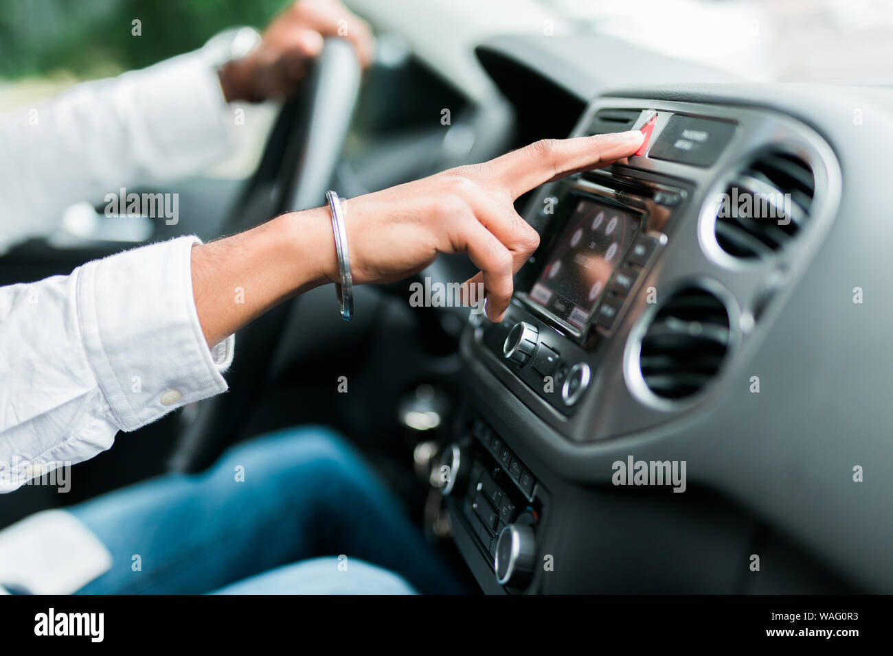 Presses the stop. Young indian man hitting car emergency red light ...