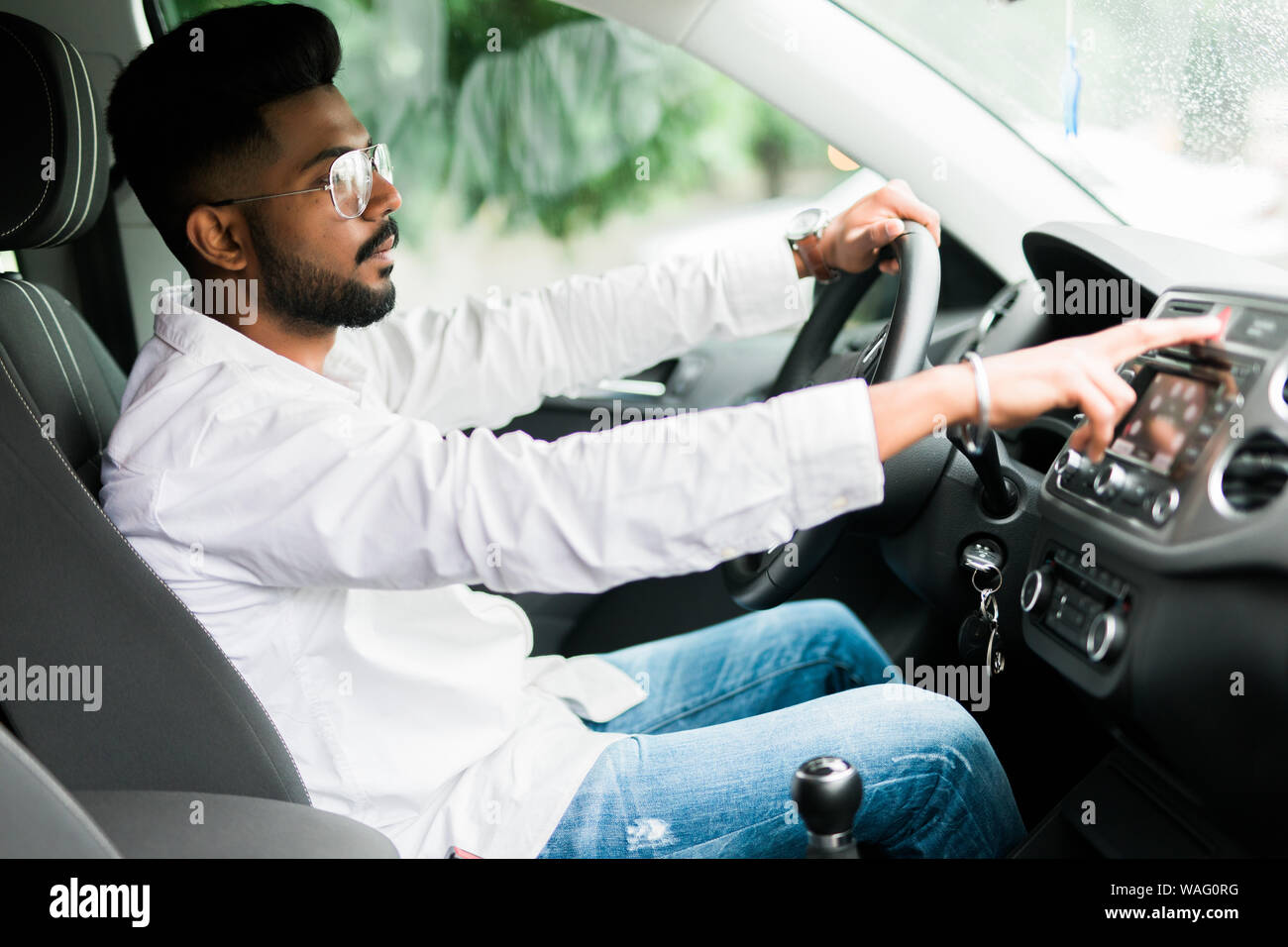 Presses the stop. Young indian man hitting car emergency red light ...