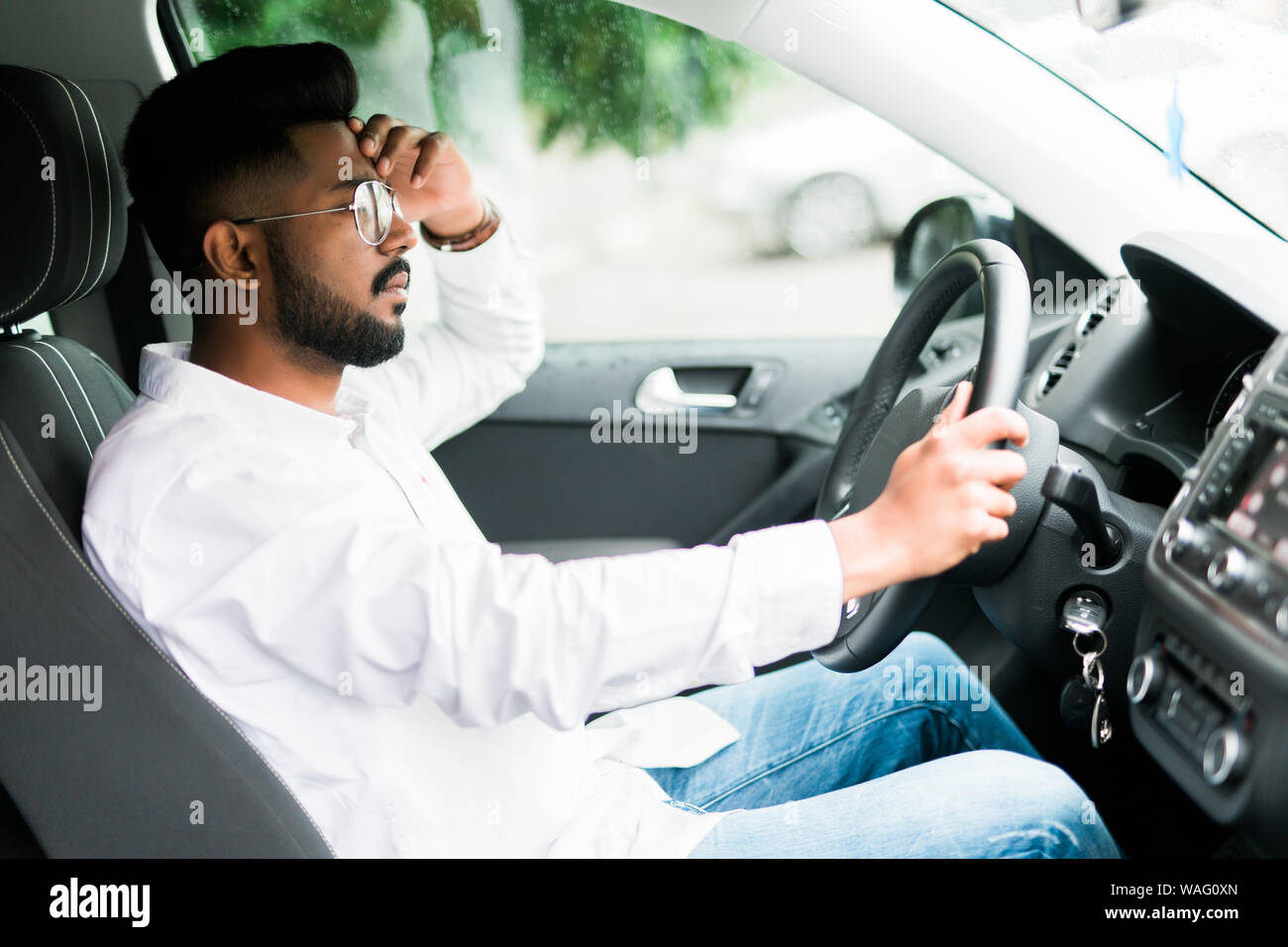 Portrait of an handsome smiling asian business man driving his car with ...