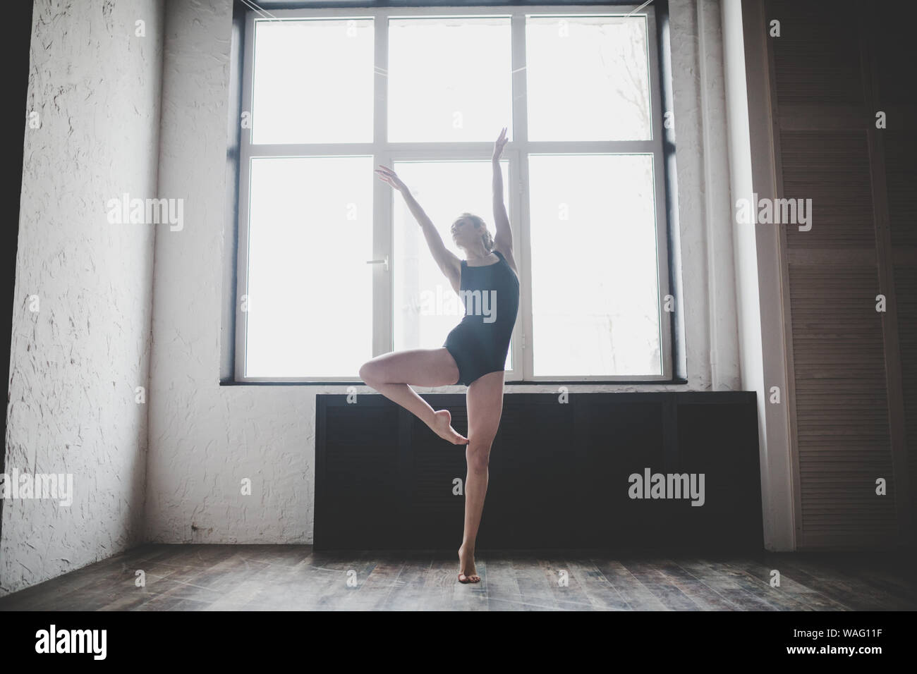 Plasticity slim woman dancing near window. Professional dancer enjoy ...