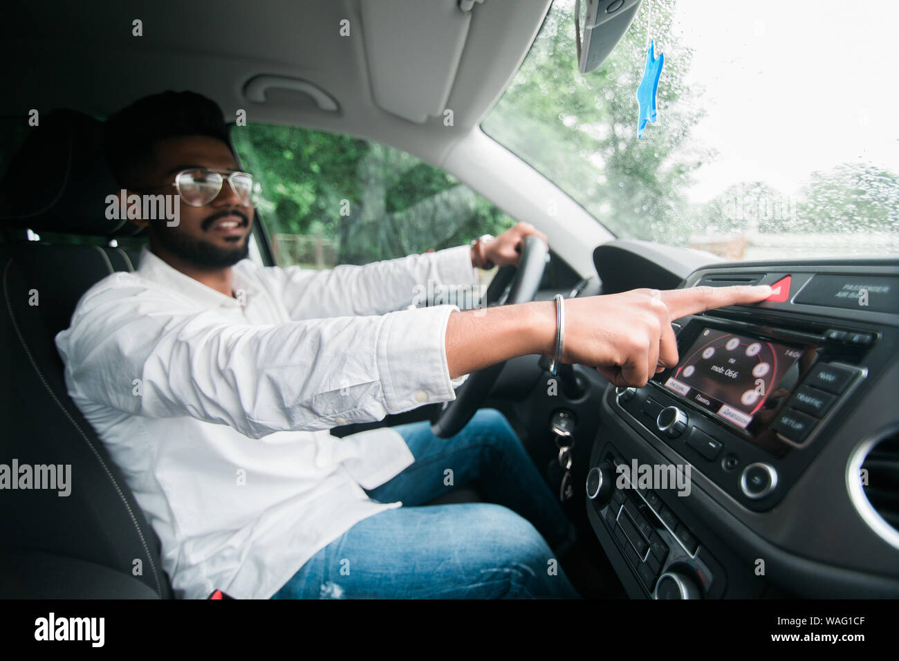 Young indian man hitting car emergency red light button in the cars ...