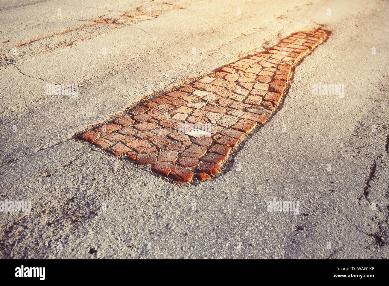 potholes in the road sealed with old bricks. Creative way to repair ...