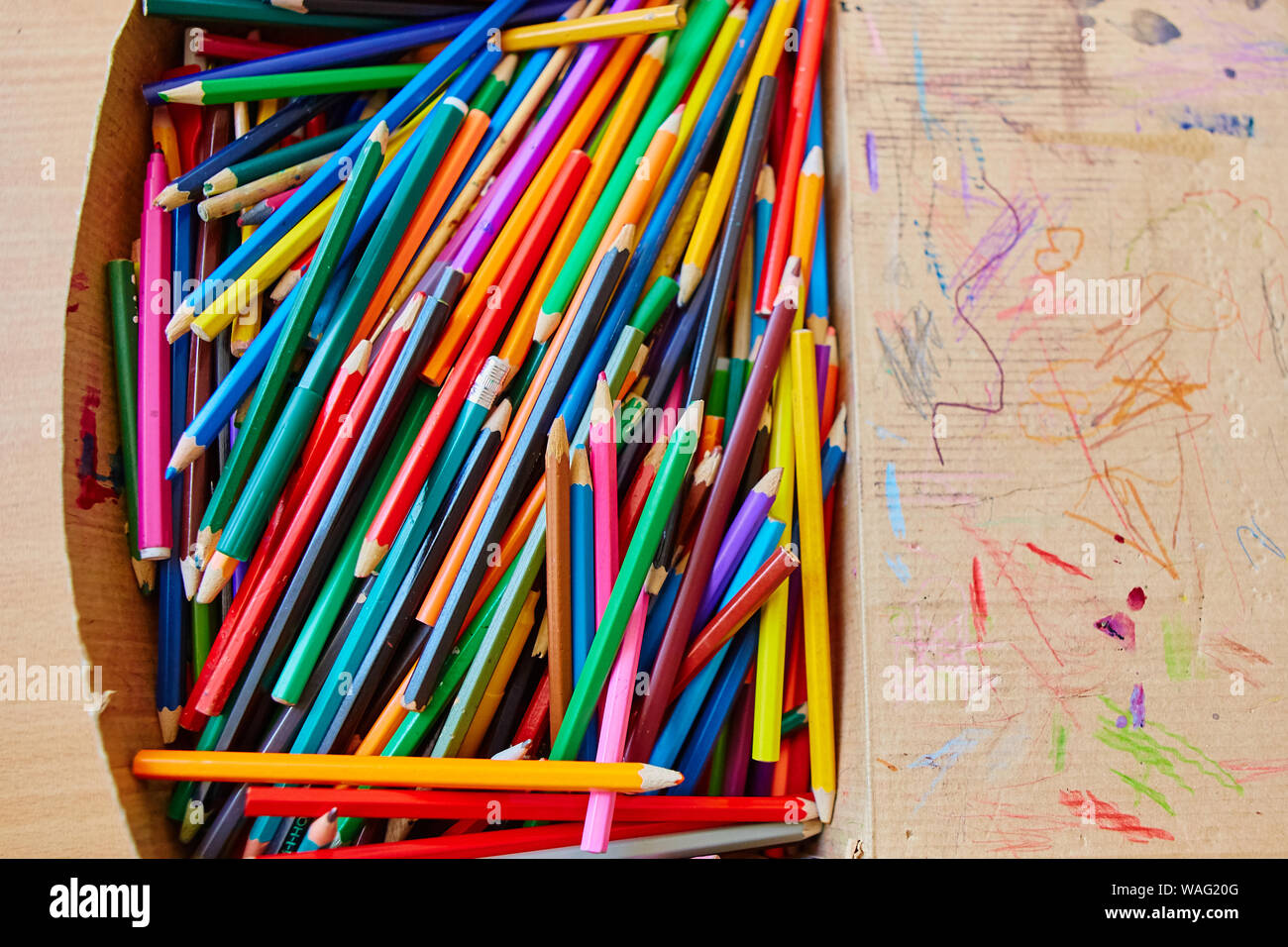 Lots of old colored wooden pencils in a cardboard box with children's ...