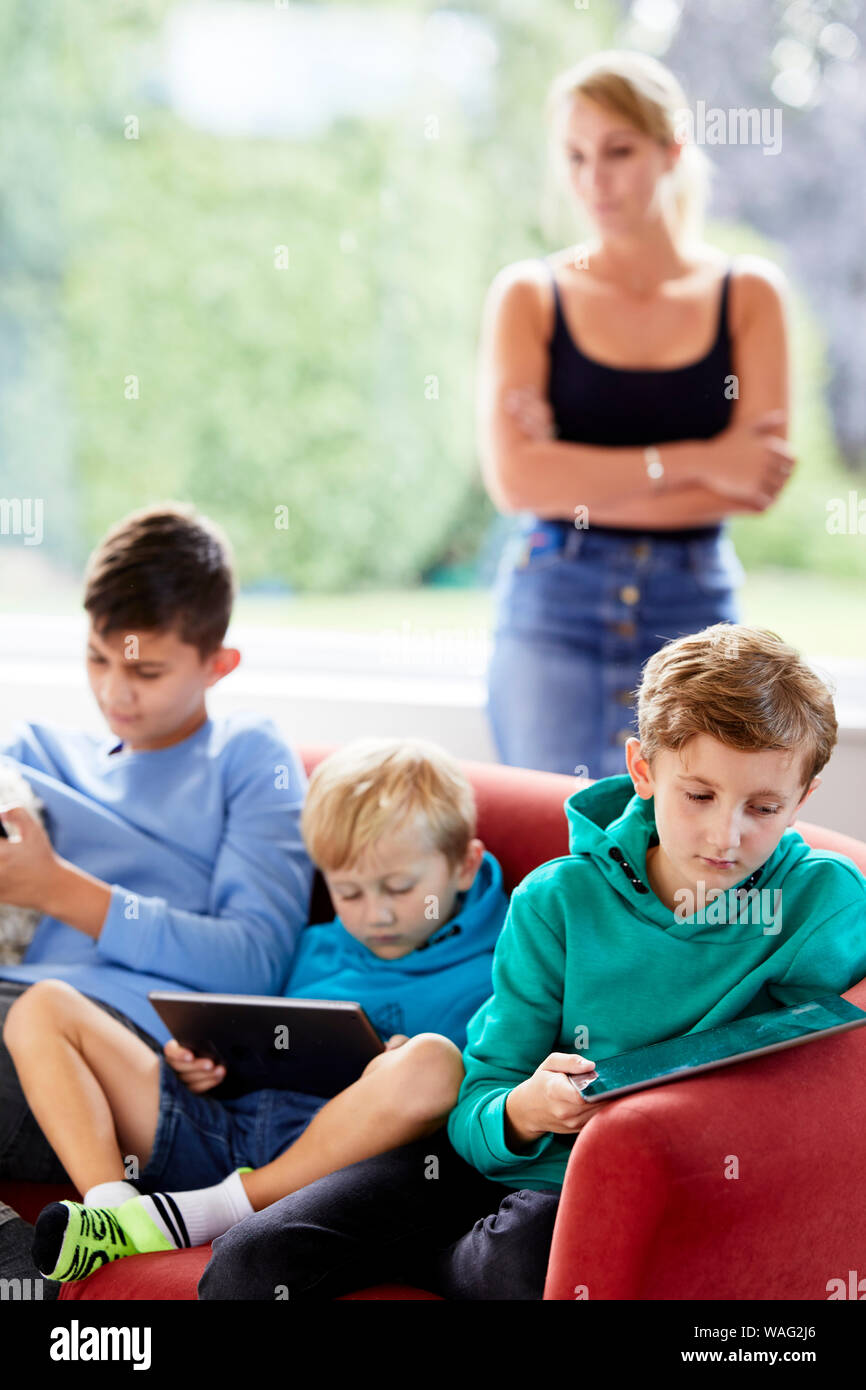 Mother watching over her children using devices Stock Photo - Alamy