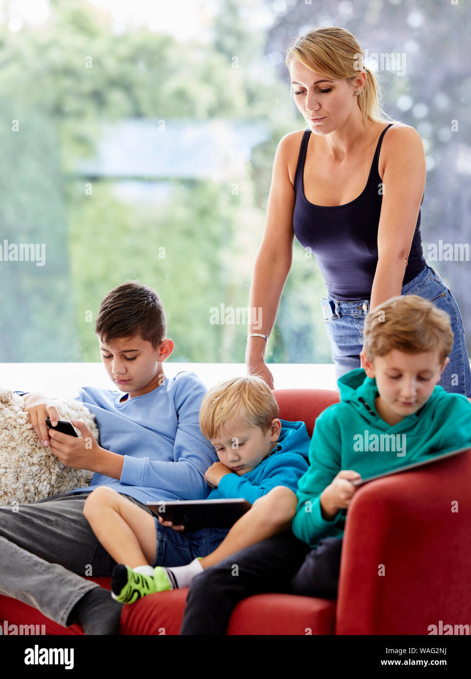 Mother watching over her children using devices Stock Photo - Alamy
