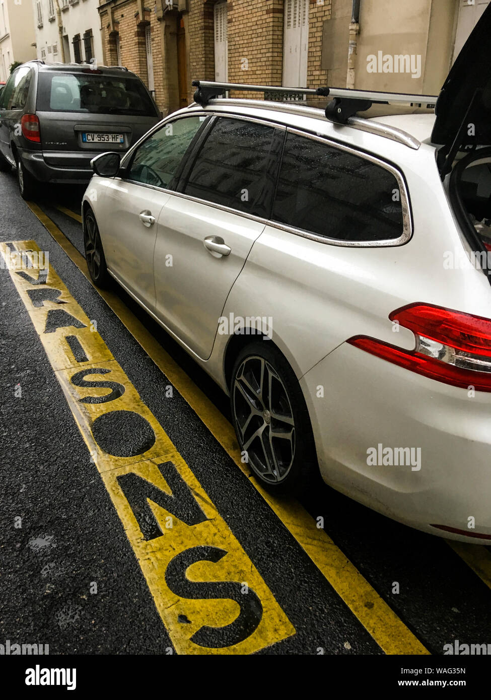A car with its rear hatch open, parked on space reserved for deliveries ...