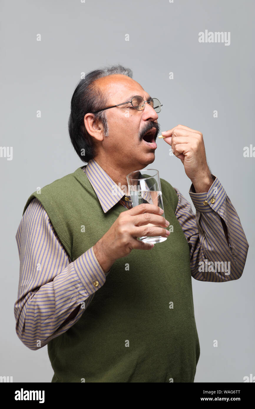 Old man taking medicine Stock Photo - Alamy