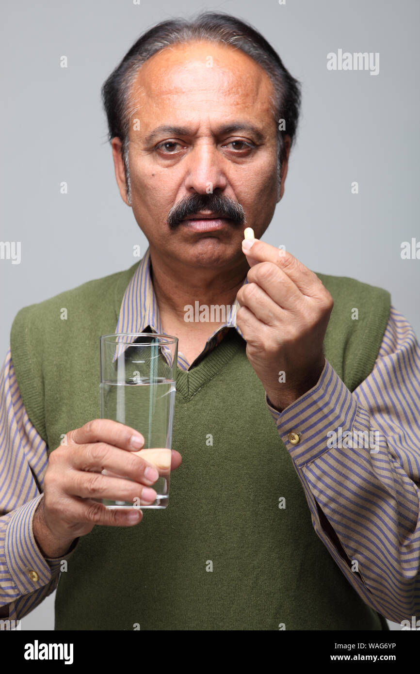 Old man taking medicine Stock Photo - Alamy