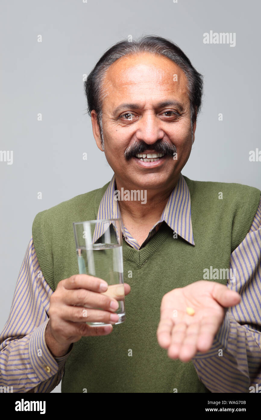 Old man taking medicine Stock Photo - Alamy