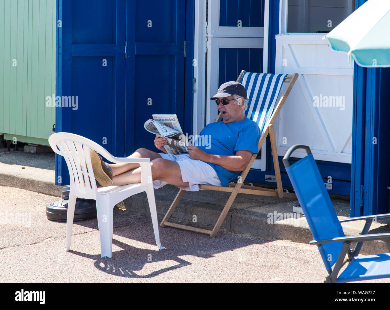 Relaxing by a beach hut Stock Photo - Alamy