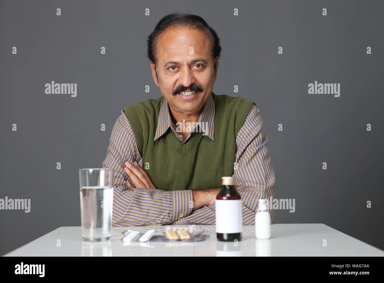 Old man sitting with his medicine Stock Photo - Alamy