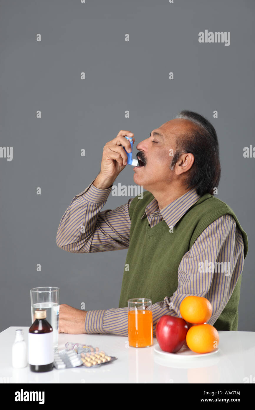 Indian old man using asthma inhaler Stock Photo - Alamy