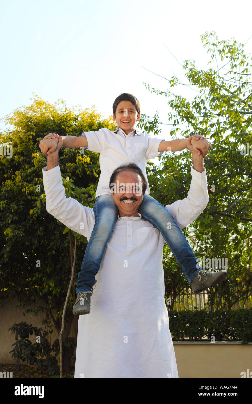 Old man carrying his grandson on his shoulder Stock Photo - Alamy