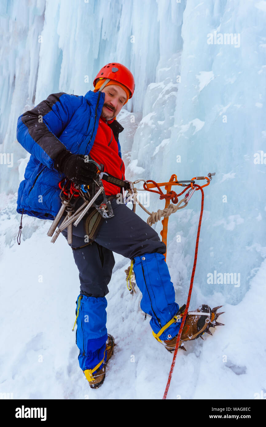 ice climber is fixed on the vertical surface of the glacier with safety ...