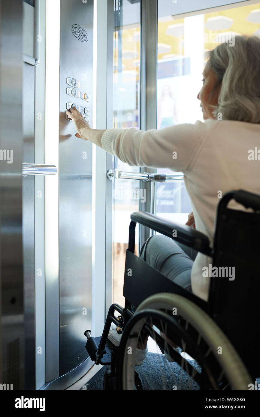 Woman holding the elevator door open hi-res stock photography and ...